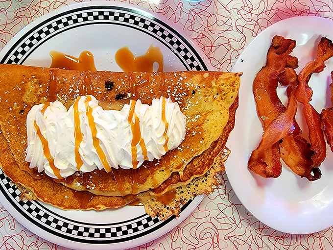 Pancakes shouldn't need their own zip code, yet here we are. That whipped cream mountain with caramel rivers would make Willy Wonka jealous.