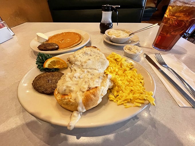 Breakfast ambition realized: golden pancakes, creamy biscuits and gravy, scrambled eggs, and savory sausage sharing a plate in perfect harmony.