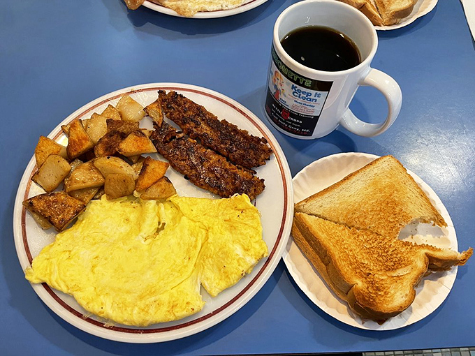 Breakfast nirvana achieved: golden home fries, perfectly crisp scrapple, fluffy eggs, and toast that makes supermarket bread weep with inadequacy.