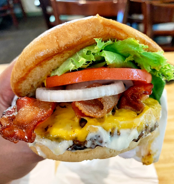 This isn't just a burger—it's a structural engineering marvel. The bacon adds that perfect smoky crunch that makes your taste buds stand up and salute.