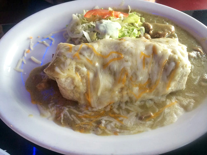 The star of the show: a green chili burrito bathed in sauce so vibrant it practically glows, topped with melted cheese that stretches with each forkful.
