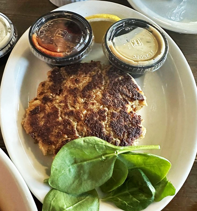 Golden-brown perfection on a plate. This crab cake contains so much actual crab, it should pay rent in the ocean.