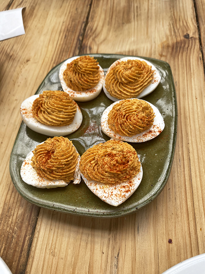 These aren't your church potluck deviled eggs. Perfectly piped, dusted with paprika, and served on a handmade plate &ndash; they're tiny works of edible art.