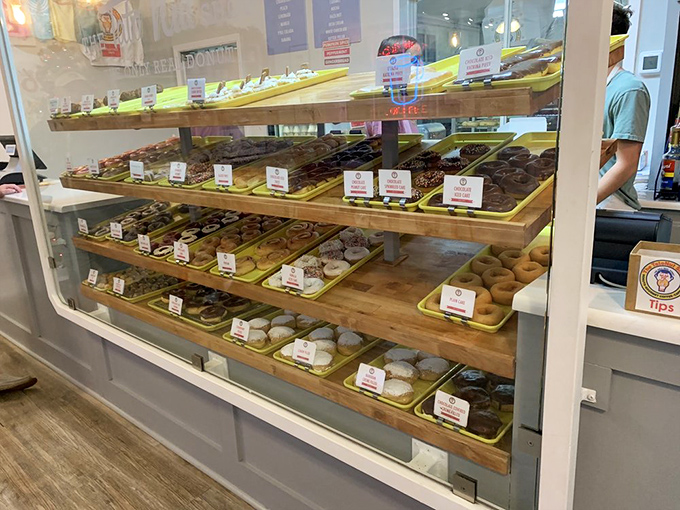 Donut display cases: where dreams are arranged in neat rows. Each tray a canvas, each pastry a masterpiece waiting for its moment of glory.