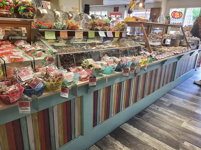 The rainbow-striped counter houses more childhood memories than your parents' attic, each glass container a time capsule of sugary nostalgia.