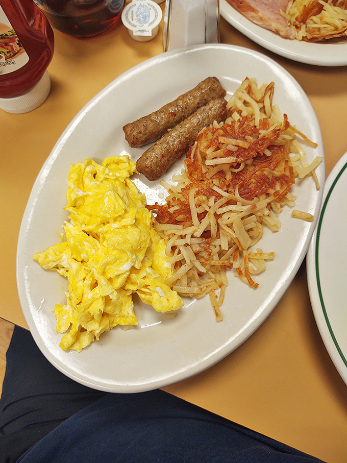 Breakfast perfection on a plate: fluffy scrambled eggs, savory sausage links, and hash browns crispy enough to make you forget your diet resolutions.