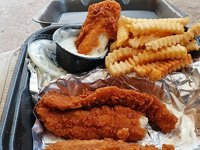 Golden-battered fish lounging on a bed of crispy fries with tartar sauce standing by. A symphony of crunch that demands your full attention.