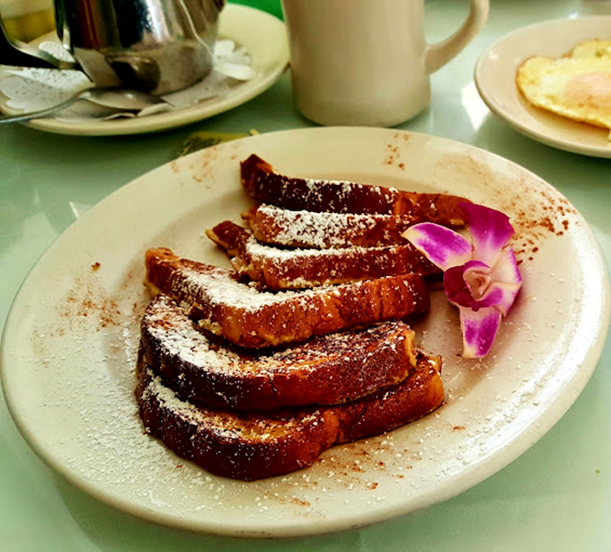 This French toast doesn't just arrive at your table&mdash;it makes an entrance, complete with powdered sugar snowfall and an edible flower entourage.