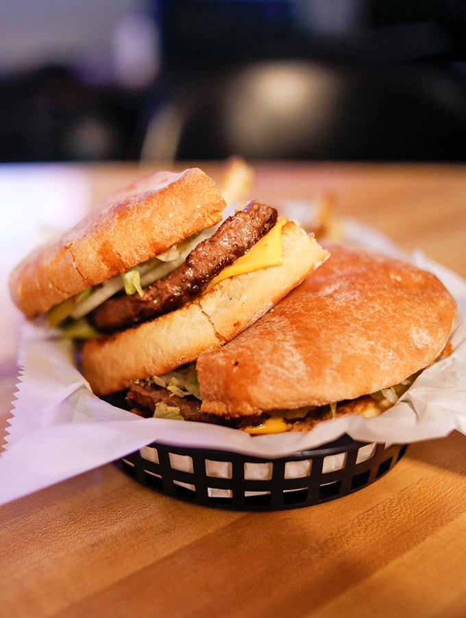 Behold the half-pounder in all its glory! This isn't just a burger&mdash;it's an architectural marvel that somehow maintains structural integrity despite its ambitions.