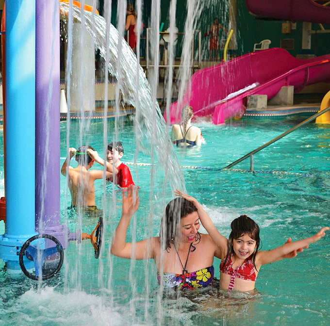 Pure joy under a waterfall. That moment when you realize indoor water features can create childhood memories just as magical as any beach vacation.