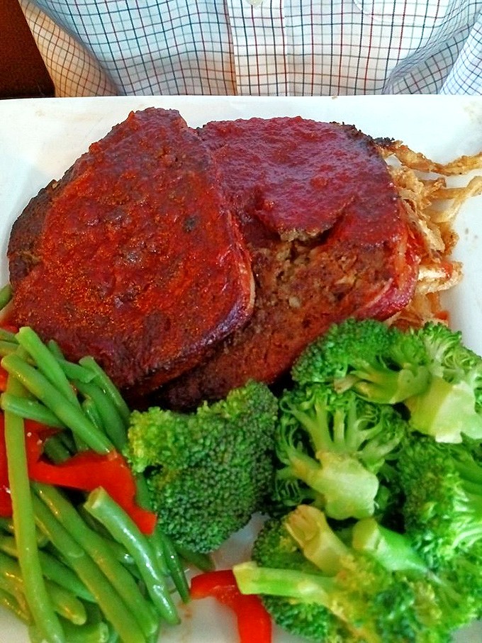 Behold the meatloaf that launched a thousand road trips. That glaze isn't just a topping; it's a religious experience with a side of perfectly crisp vegetables.