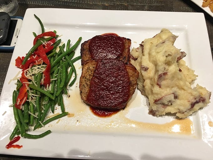 Behold the holy trinity of comfort: meatloaf glazed to perfection, garlic mashed potatoes that your spoon will dive into, and vibrant green beans.