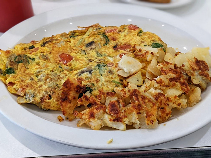 Behold the omelet that launched a thousand satisfied sighs. Golden perfection meets crispy potatoes in a breakfast symphony that Mozart would have ordered.