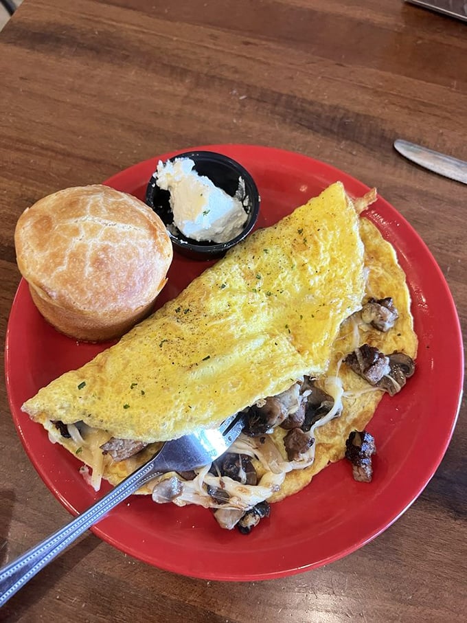 This isn't just an omelette&mdash;it's a golden envelope stuffed with a love letter of mushrooms and cheese, accompanied by a biscuit that deserves its own fan club.