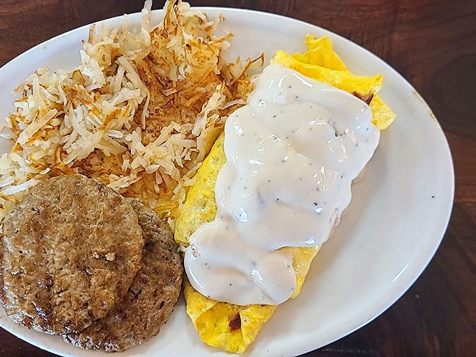 Behold the omelet that launched a thousand road trips. Perfectly folded eggs, smothered in country gravy, with hash browns crisped to golden perfection.