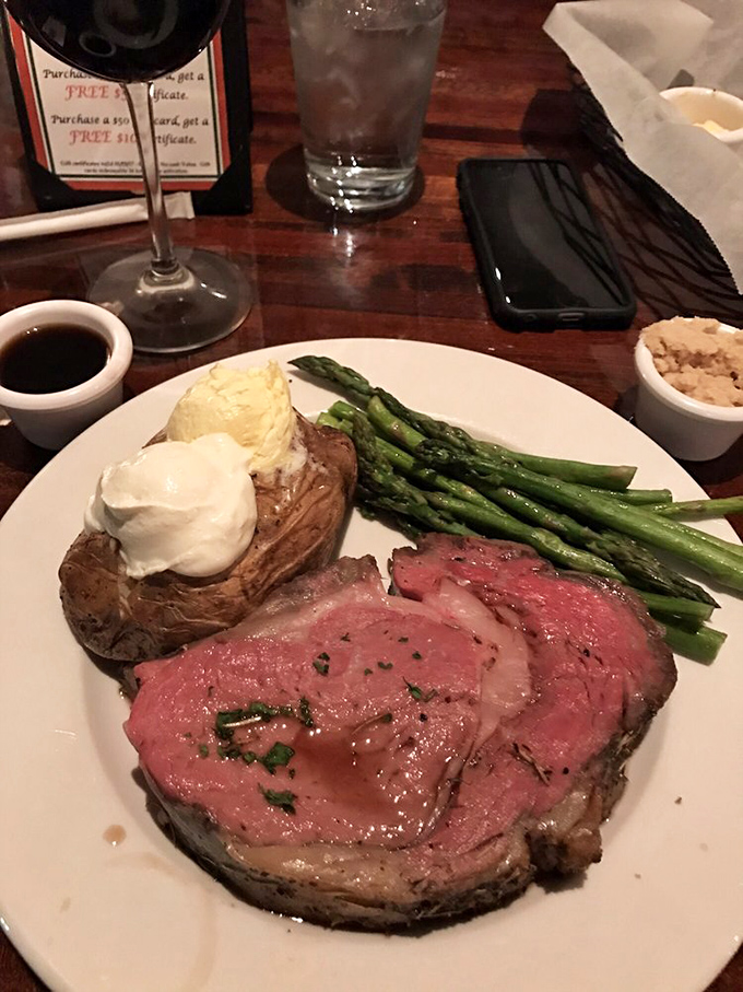 Prime rib perfection that would make Ron Swanson weep tears of joy. The baked potato sidekick deserves its own fan club.