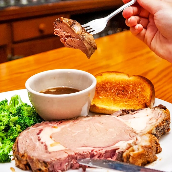Behold the star of the show! This prime rib isn't just cooked&mdash;it's coaxed to perfection, its juices asking to be sopped up with that Texas toast.