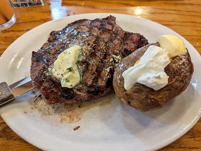 Prime rib that would make a vegetarian weep with regret, accompanied by a baked potato dressed for a formal occasion.