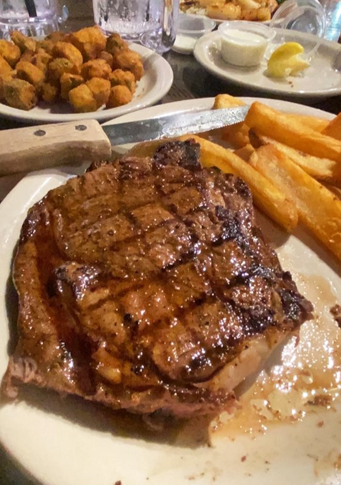 Behold the ribeye in its natural habitat&mdash;perfectly cross-hatched and glistening with juices. Those fries aren't sidekicks; they're worthy companions on this plate of joy.