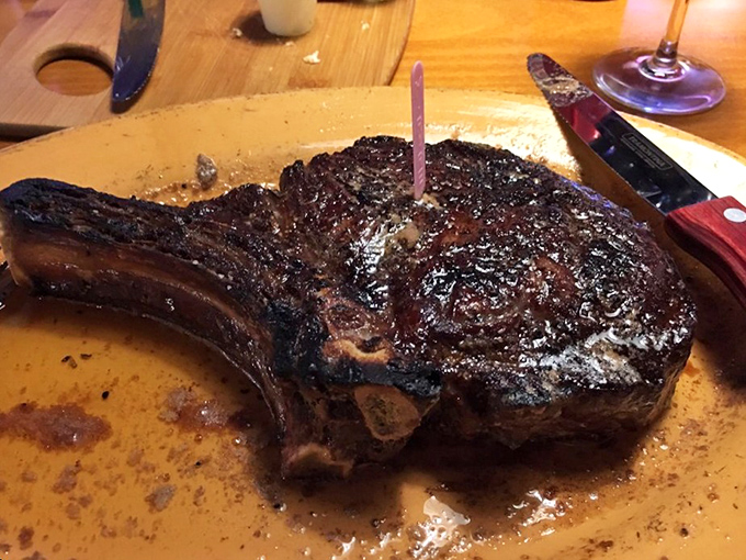 The bone-in ribeye arrives like a prehistoric masterpiece&mdash;a caveman's dream with a PhD in flavor development.