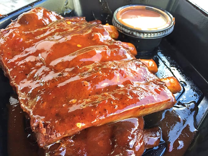 These ribs aren't just cooked, they're serenaded with smoke until they reach a state of glistening perfection. The sauce cup is just showing off.
