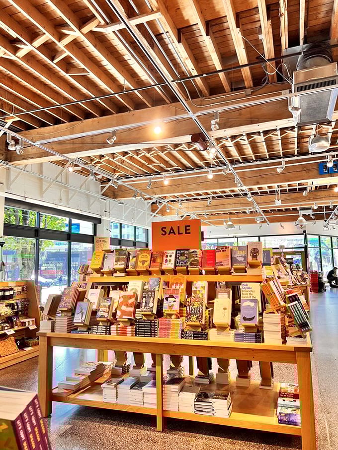 Sunlight streams through windows illuminating a display table where books bask like sunbathers, their colorful covers competing for your attention and wallet.