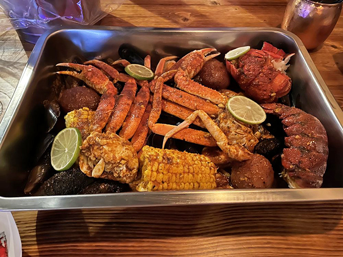 Snow crab legs stretch across the metal tray like delicious sunbeams, while potatoes and corn play supporting roles in this seafood symphony.