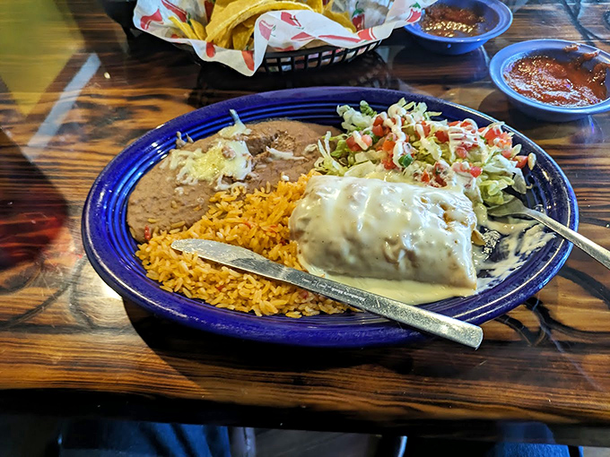 Behold the burrito in its natural habitat&mdash;swimming in sauce, surrounded by rice and beans. This plate doesn't just feed you; it embraces you.