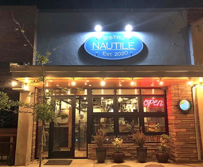 By night, Bistro Nautile transforms into a twinkling seafood sanctuary where string lights and wine glasses create pure magic.