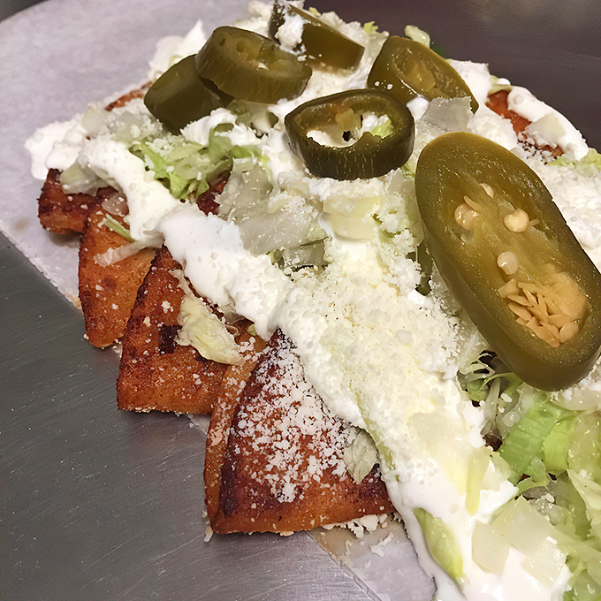 Jalape&ntilde;os standing guard over enchiladas like tiny green sentinels of spice. They're not just garnish&mdash;they're a flavor promise.