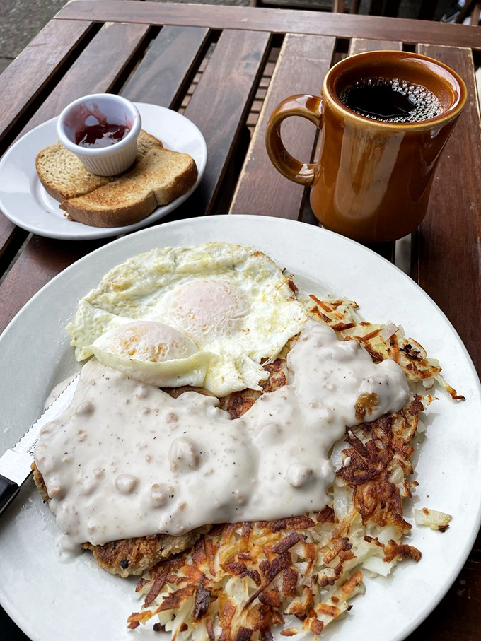 Country fried steak with gravy that could make a vegetarian question their life choices. The coffee mug stands guard.