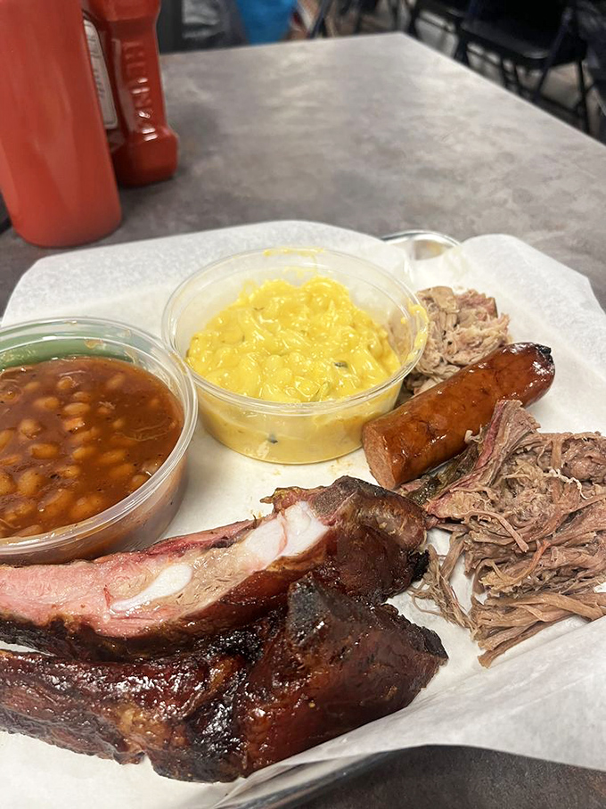 The barbecue grand tour: smoky ribs, tender pulled pork, snappy sausage, and sides that don't play second fiddle. A symphony of smoke on a humble tray.
