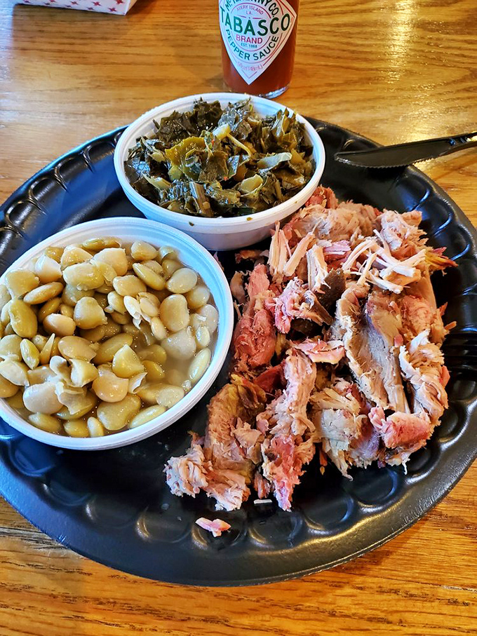 This pulled pork plate isn't just a meal; it's a meditation on smoke, time, and tradition, accompanied by beans and greens done right.