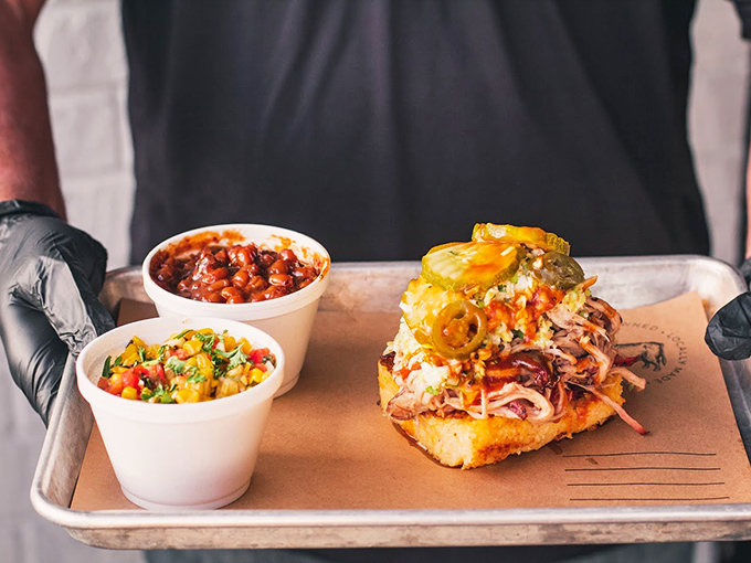 This isn't just a sandwich; it's an architectural marvel of pulled pork, slaw, and jalape&ntilde;os that requires both hands and possibly a bib.