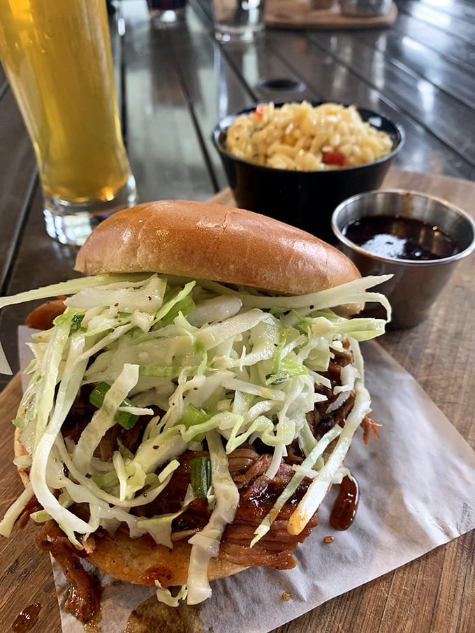 The pulled pork sandwich, topped with a mountain of fresh slaw, sits ready to transport you to barbecue nirvana with each bite.