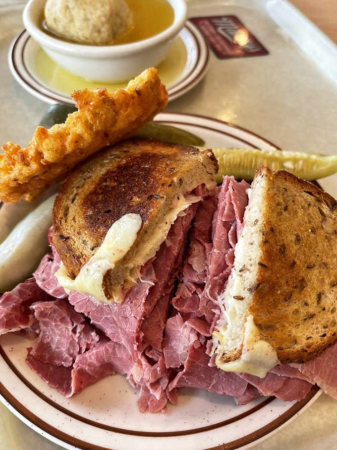 The Reuben in its natural habitat, flanked by matzo ball soup and a potato pancake&mdash;the holy trinity of deli comfort.