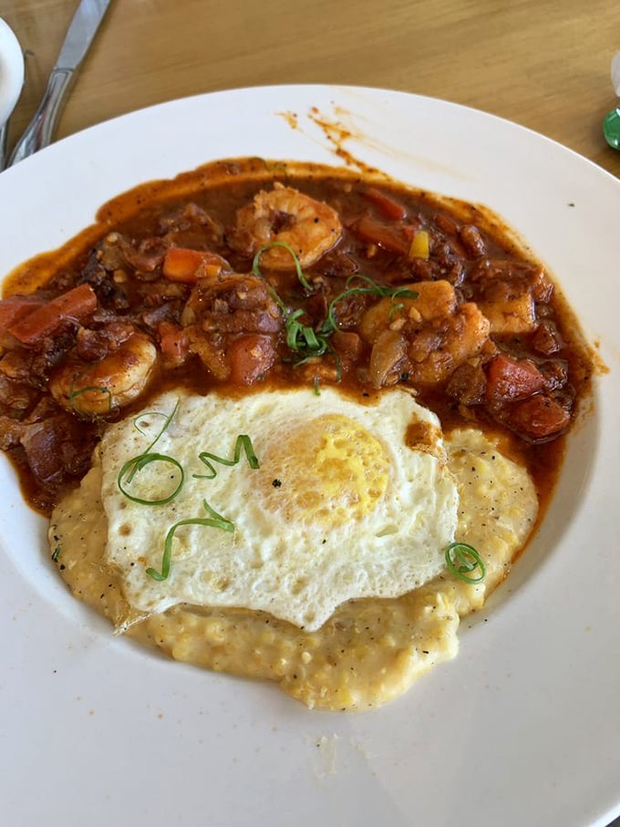The fried egg perched atop this shrimp and grits masterpiece isn't just a topping&mdash;it's the breakfast equivalent of putting a cherry on a sundae. Pure genius.