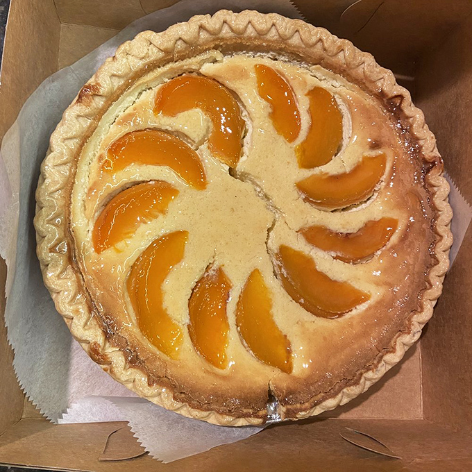 Apricot slices dance across this custard pie like synchronized swimmers in a golden pool. Whoever invented this deserves a Nobel Prize in Deliciousness.