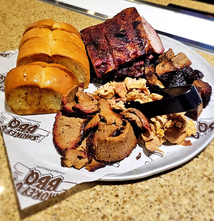 This BBQ sampler platter isn't just a meal, it's a meat manifesto&mdash;ribs, brisket, and sausage with Texas toast standing by for support.