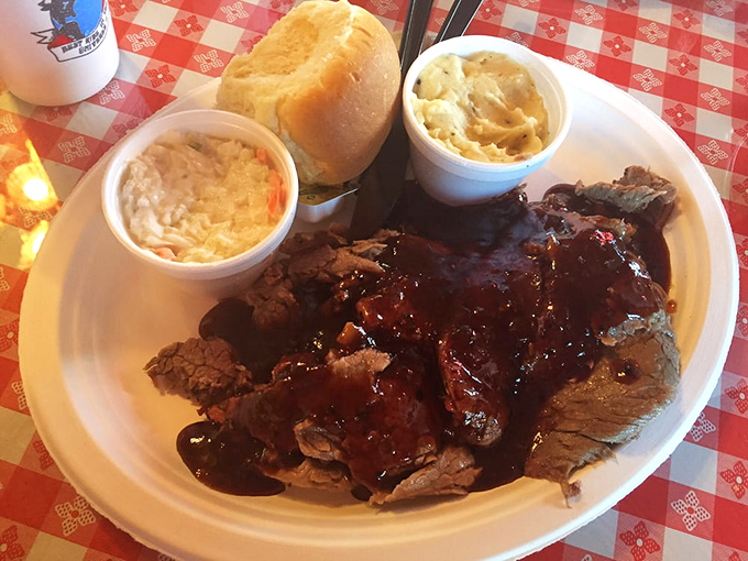 This isn't just dinner, it's a declaration of love&mdash;smoke-kissed brisket glistening with sauce, flanked by loyal companions of coleslaw and potato salad.