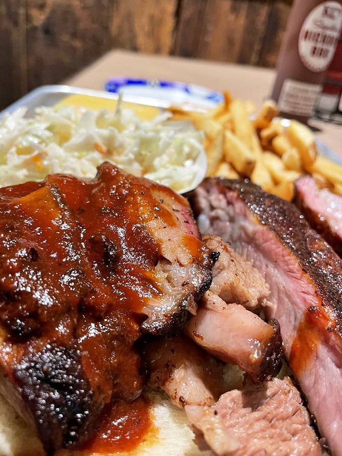 Behold the holy trinity: perfectly smoked brisket with that pink smoke ring, tangy sauce, and sides that know their supporting role.