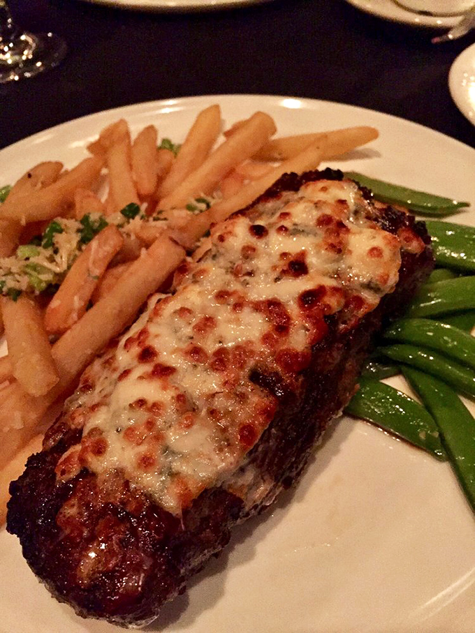 The "black and blue" New York strip arrives with a crust that would make a French pastry chef jealous. Cheese melting like a Salvador Dal&iacute; clock.