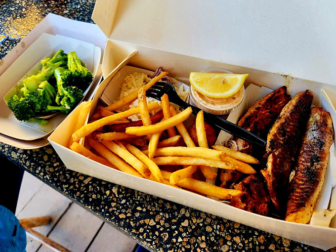 The perfect trifecta: golden fries, vibrant broccoli, and blackened mullet that would make Neptune himself swim to shore.