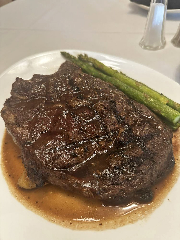 This isn't just a steak &ndash; it's a ribeye with ambition, glistening in its own savory juices alongside asparagus that actually deserves to be eaten.