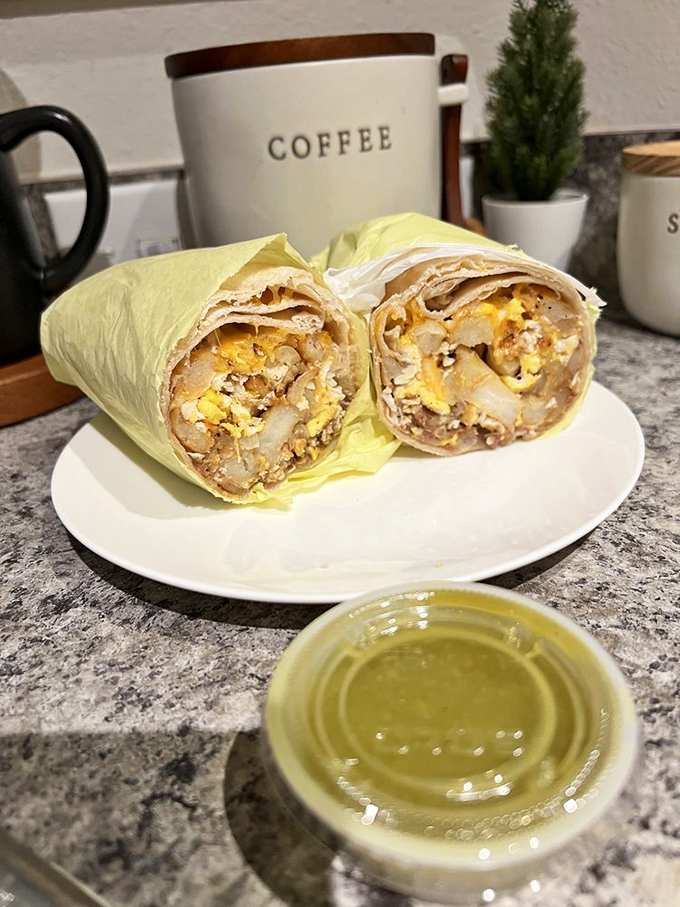 Breakfast of champions! Eggs, potatoes, and protein nestled in a golden tortilla with that vibrant green salsa standing by. Morning meetings can definitely wait.