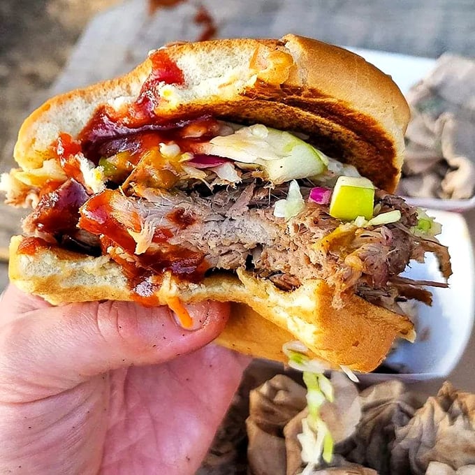 This pulled pork sandwich isn't just lunch &ndash; it's an architectural marvel of smoke, sauce, and slaw that demands a two-handed commitment.