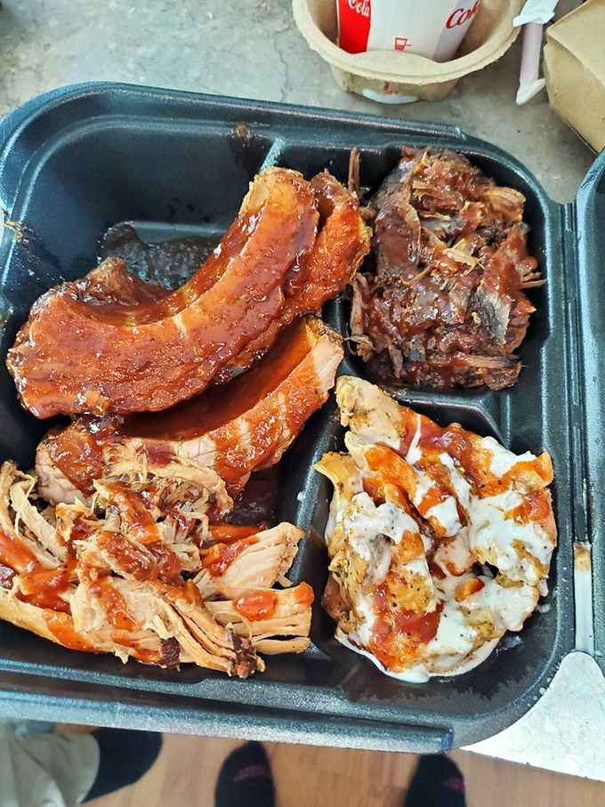 This tray contains approximately 2,000 calories of pure, unadulterated joy. The meat trinity&mdash;ribs, pulled pork, and chicken&mdash;sharing real estate in BBQ harmony.