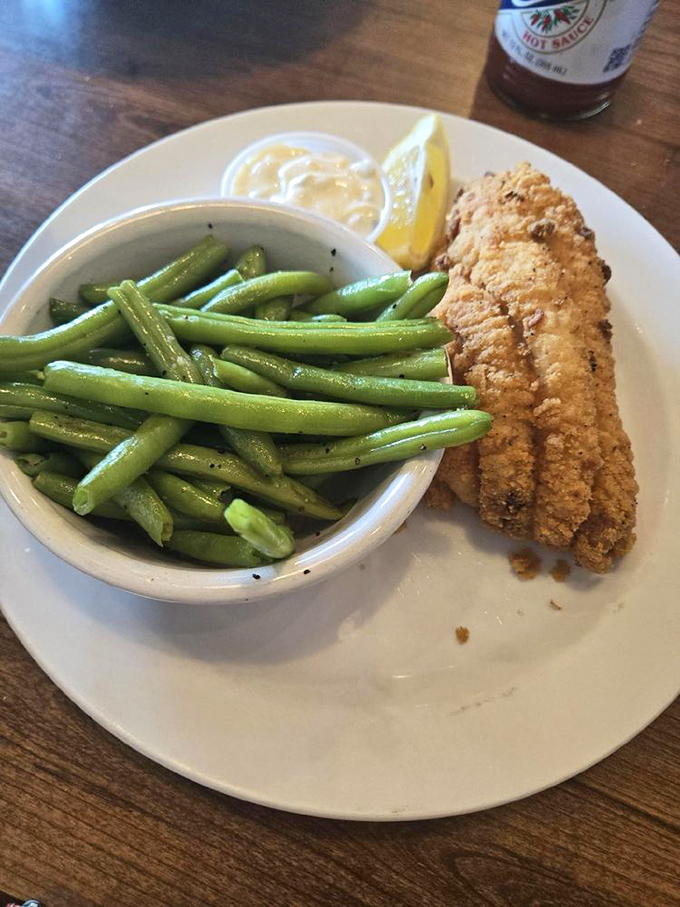 Perfectly fried catfish meets vibrant green beans&mdash;a plate that balances indulgence and virtue like a tightrope walker at a food circus.