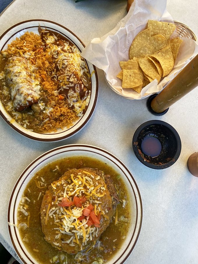 A cheese enchilada swimming in sauce alongside a crispy chile relleno—proof that the best relationships are built on complementary differences.