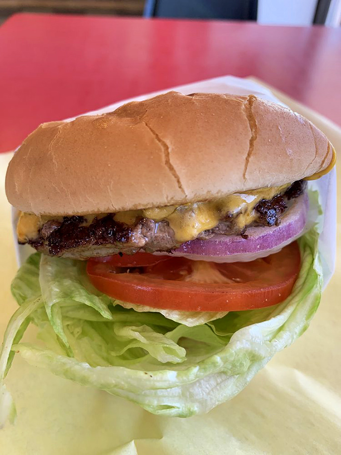 Behold the cheeseburger in its natural habitat – perfectly melted cheese cascading over a beautifully charred patty. Poetry on a bun.